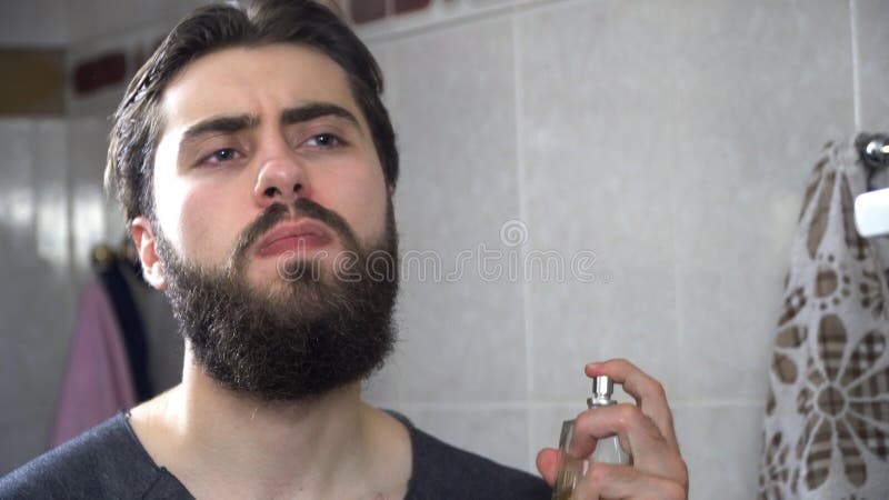Handsome Man Using Perfume in Front of Mirror. Handsome Man Applying ...