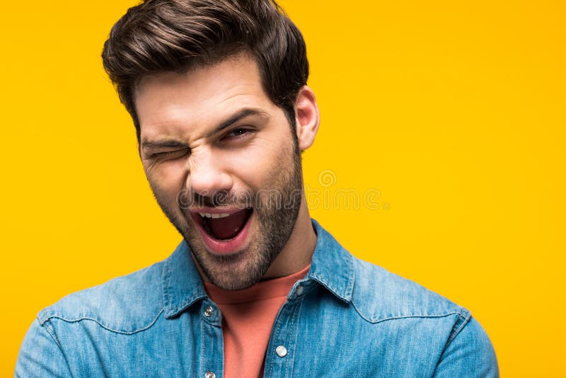 Handsome Man Winking and Looking at Camera Isolated on Yellow Stock ...