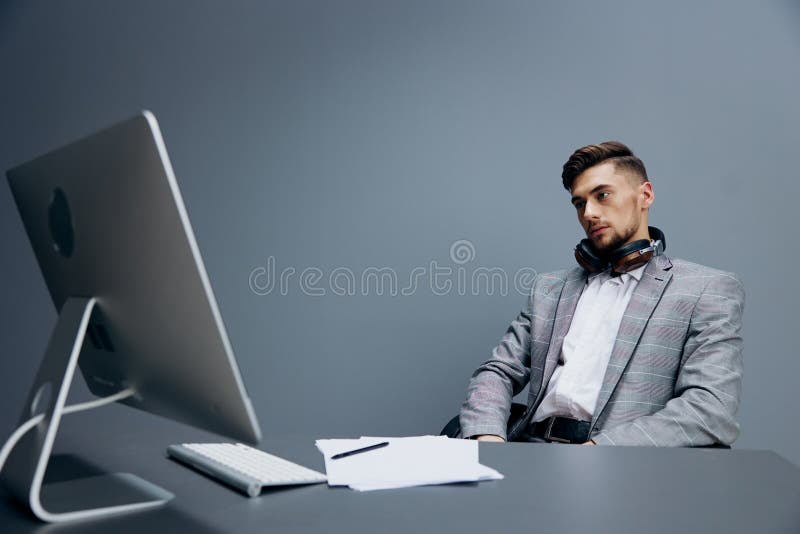Handsome Man Working at the Computer in Headphones in the Office ...