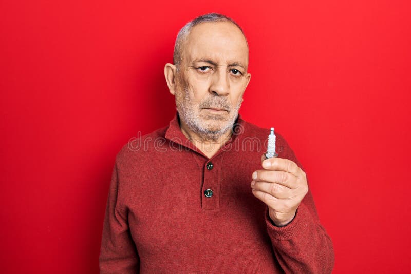 Handsome Mature Man Holding Spark Plug Thinking Attitude and Sober ...