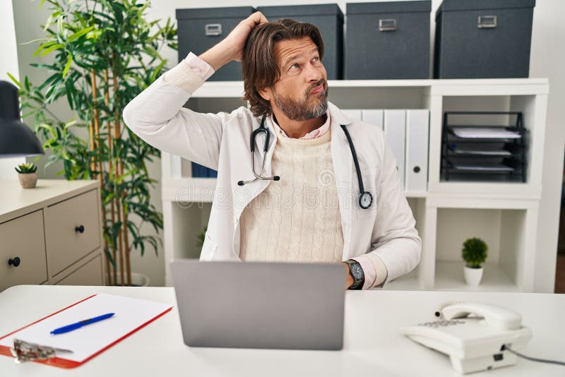 Handsome Middle Age Doctor Man Working at the Clinic Confuse and ...