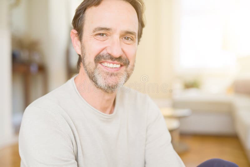 Handsome Middle Age Man Sitting on the Floor Smiling at the Camera at ...