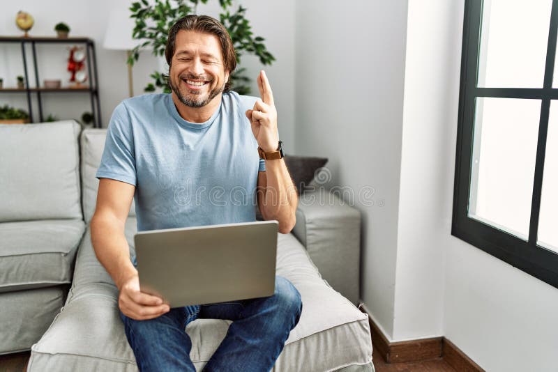 Handsome Middle Age Man Using Computer Laptop on the Sofa Gesturing ...