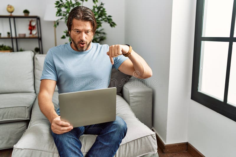 Handsome Middle Age Man Using Computer Laptop on the Sofa Pointing Down ...