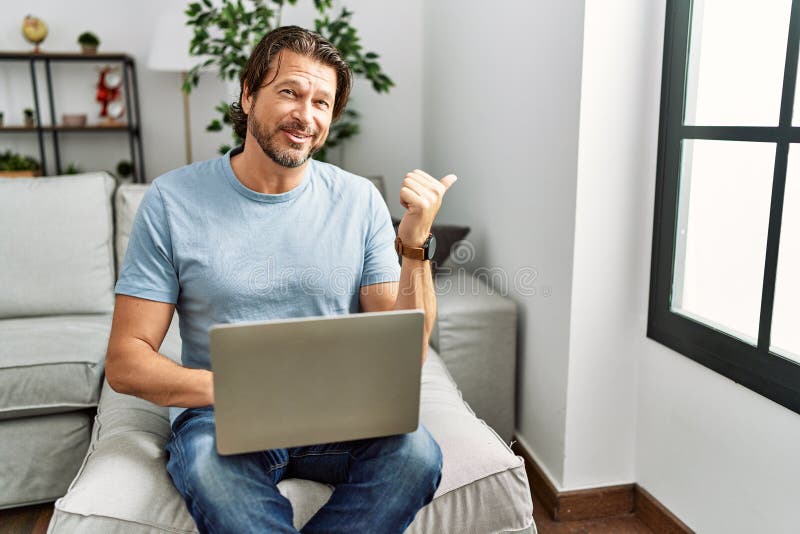 Handsome Middle Age Man Using Computer Laptop on the Sofa Pointing To ...