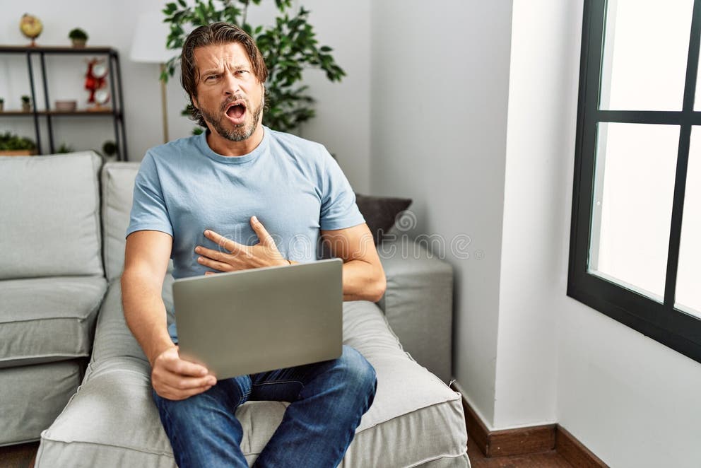 Handsome Middle Age Man Using Computer Laptop on the Sofa in Shock Face ...