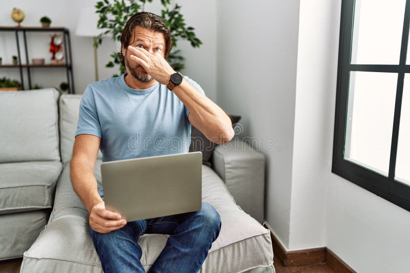 Handsome Middle Age Man Using Computer Laptop on the Sofa Smelling ...