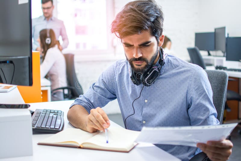 Handsome Mixed Race Man Checking daily Report Containing Relevant Work ...