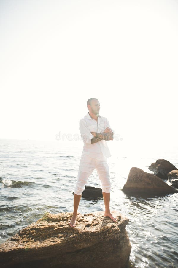 Handsome Model Man Posing on Stone by the Sea Stock Photo - Image of ...