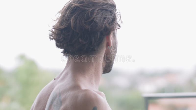 Handsome Muscular Man with Tattoos on His Bare Back Step Out Onto the ...