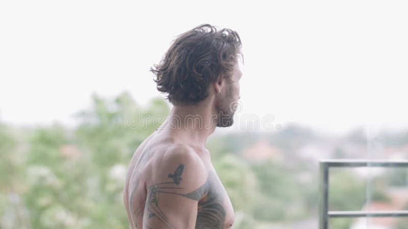 Handsome Muscular Man with Tattoos on His Bare Back Step Out Onto the ...