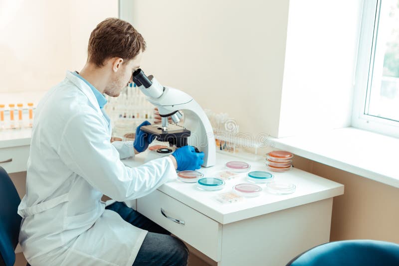 Handsome Nice Man Sitting in Front of the Microscope Stock Image ...
