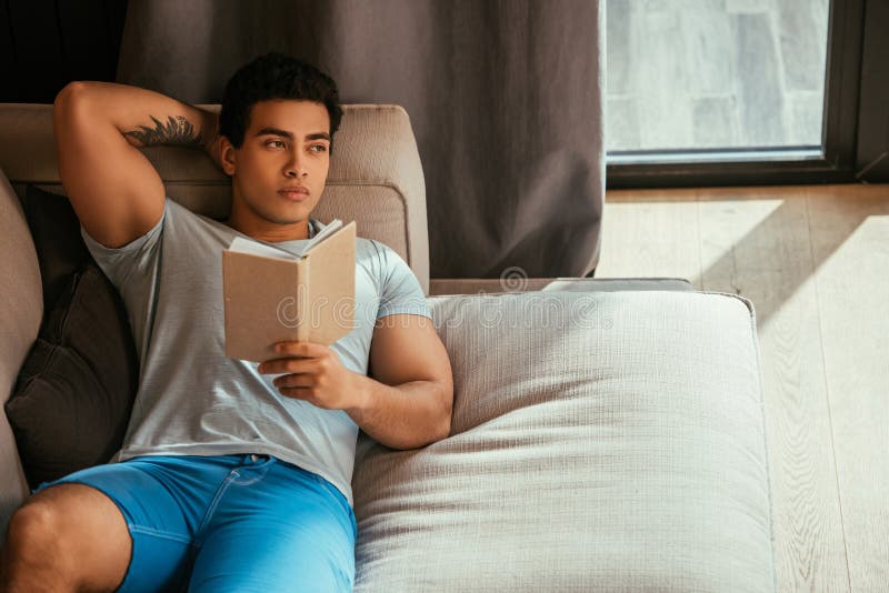 Handsome Pensive Man Reading Book while Stock Image - Image of ...