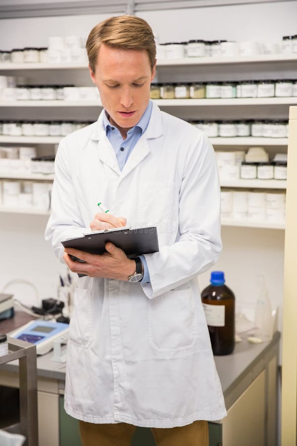 Handsome Pharmacist Writing on Clipboard Stock Photo - Image of ...