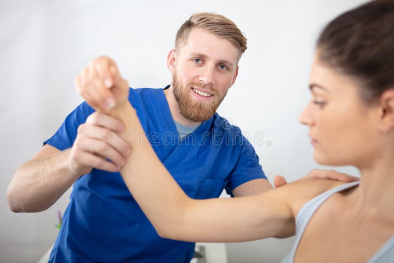 Handsome Physiotherapist Treating Patients Shoulder Stock Image - Image ...