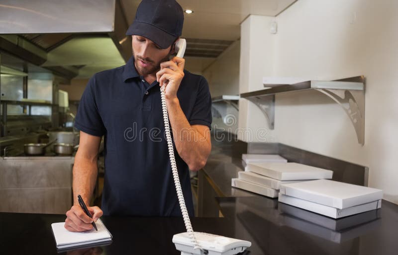 Handsome Pizza Delivery Man Taking an Order Over the Phone Stock Photo ...