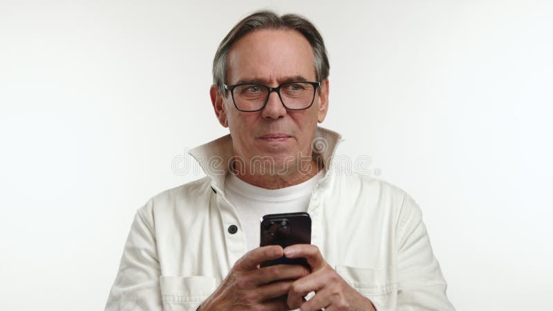 Joyful Senior Man Texting on Smartphone in Youthful Jacket on White ...