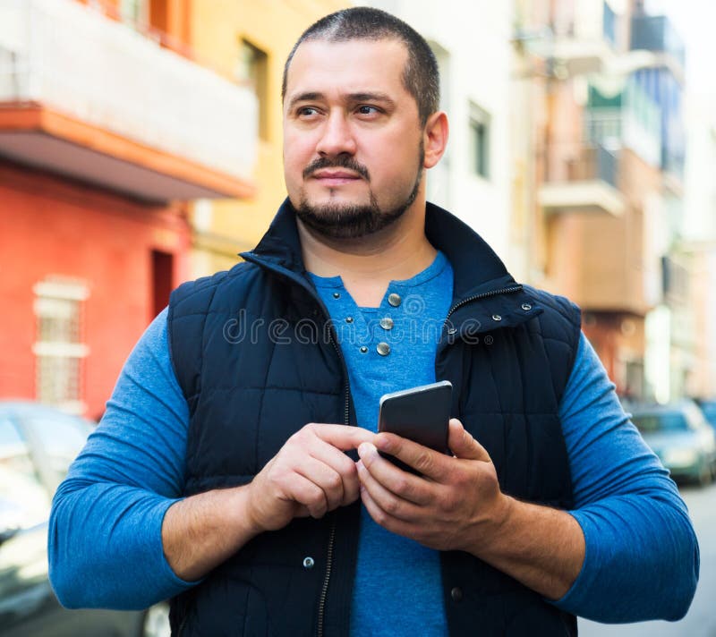 Man on street with phone stock photo. Image of connection - 225982334