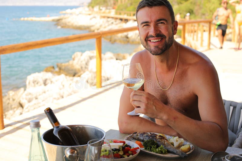 Handsome Shirtless Man Eating Fresh Grilled Fish at a Beach Stock Image ...