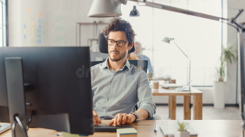 Handsome and Smart Hispanic Office Employee Sitting at His Desk Works ...