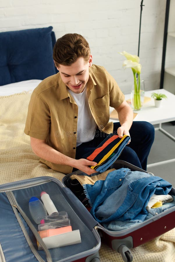 Handsome Smiling Man Packing Clothes Stock Photo - Image of tourist ...
