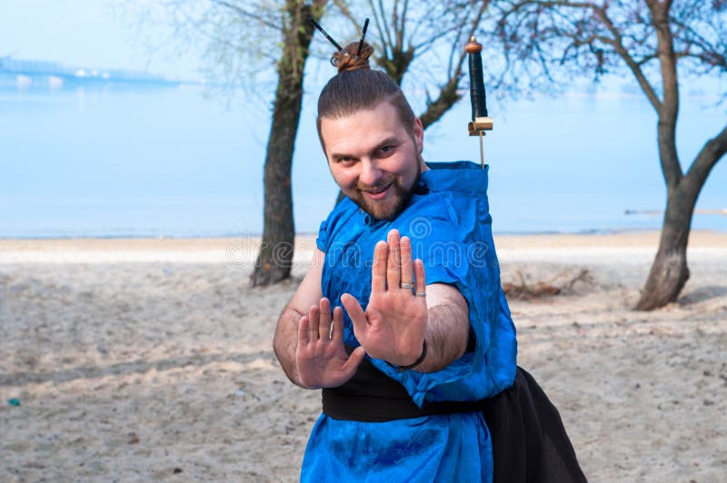 Handsome Smiling Samurai in Blue Kimono, Bun and Sticks on Head ...