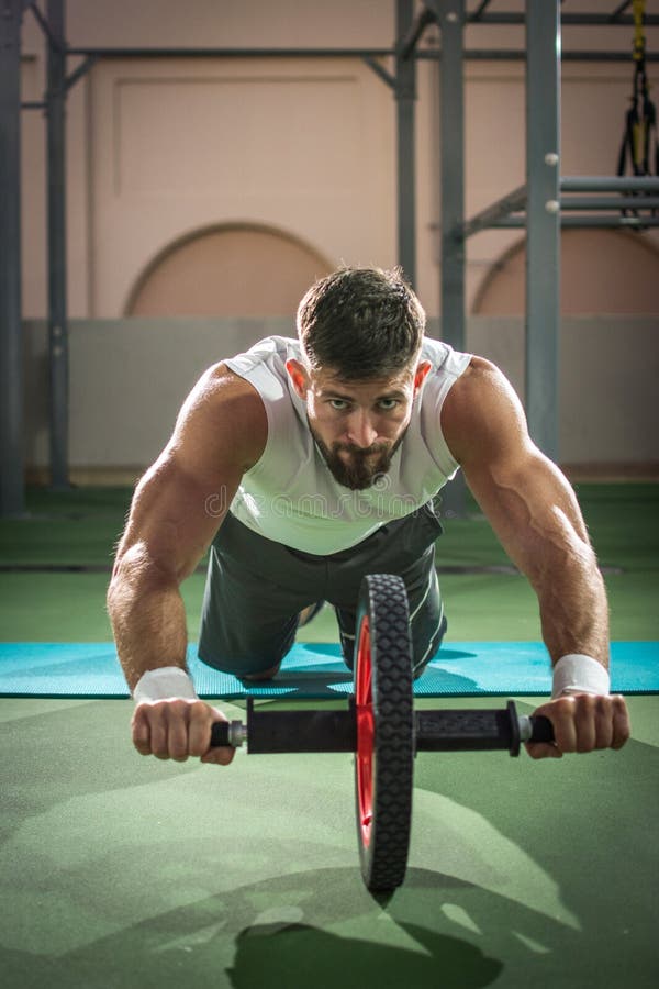 Handsome Sportsman Doing Ab Wheel Rollout Exercise and Looking Forward ...