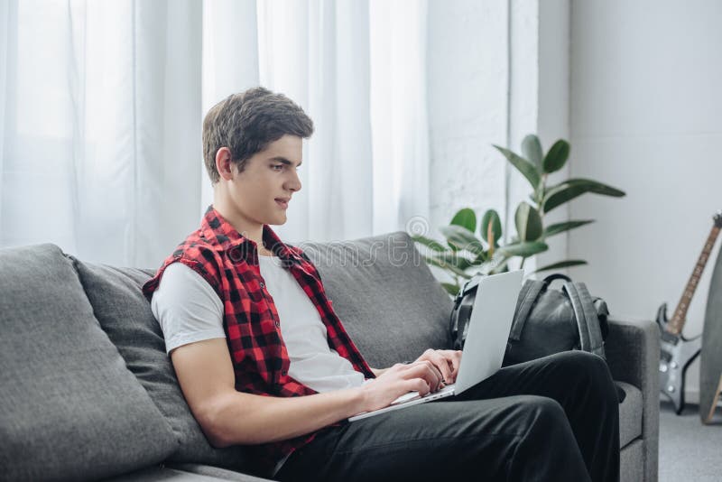 Handsome Teenager Typing on Laptop while Sitting Stock Photo - Image of ...