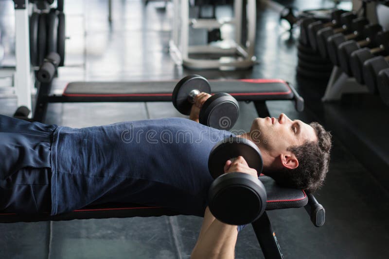 Handsome Weightlifter Lifting Bench Press Working Out with Dumbbell in ...