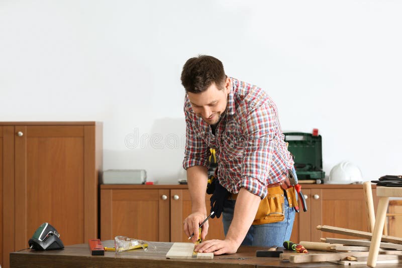 Handsome Working Man Making Marks on Timber at Table. Home Repair Stock ...