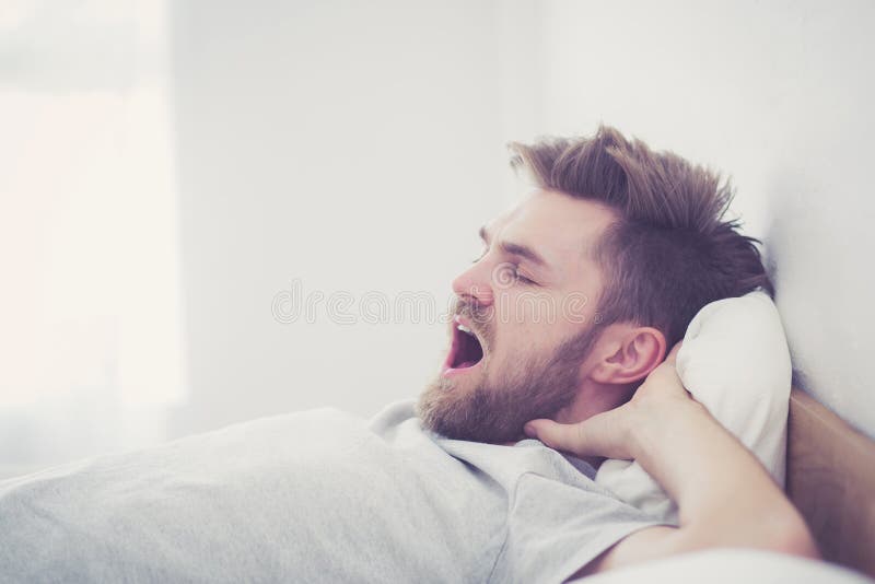 Handsome Young American Male Yawn Sleeping In Bed At Home Stock Image
