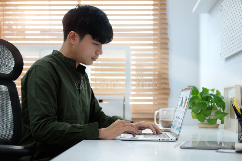 Handsome Young Asian Man Working Online with Laptop Computer at Modern ...