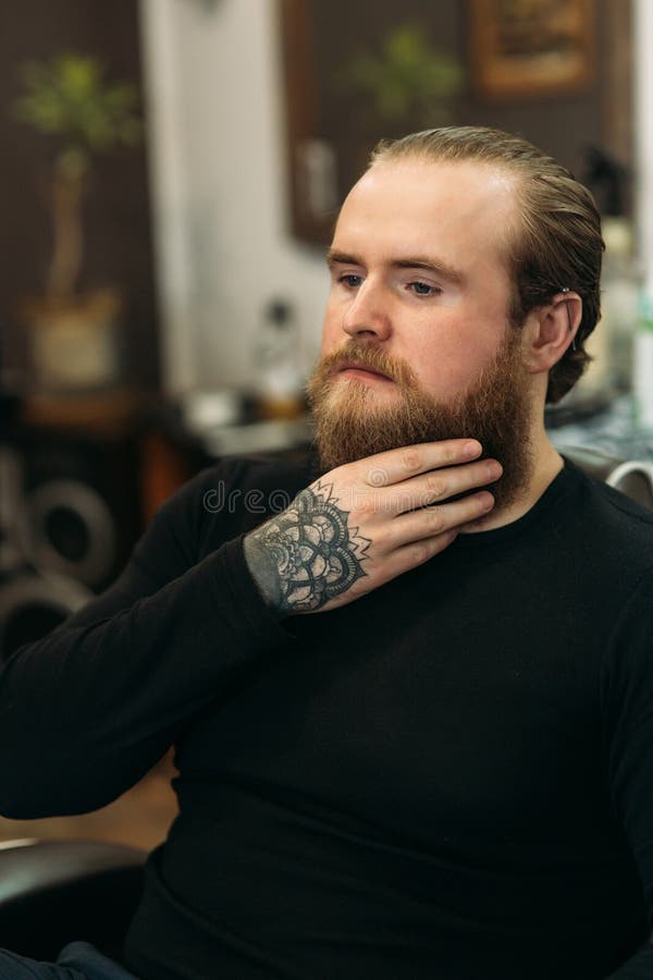 Handsome Young Bearded Guy Sitting in an Armchair in a Beauty Salon ... Handsome Young Bearded Guy Sitting in an Armchair in a Beauty Salon ...