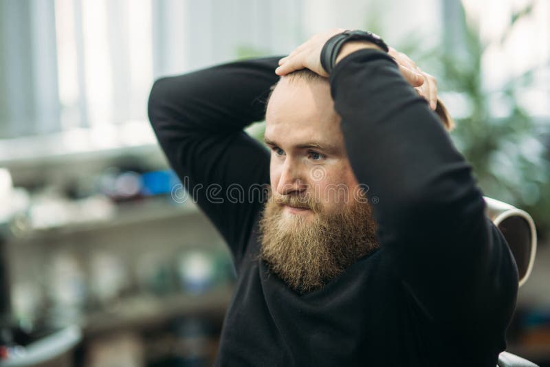 Handsome Young Bearded Guy Sitting in an Armchair in a Beauty Salon ... Handsome Young Bearded Guy Sitting in an Armchair in a Beauty Salon ...