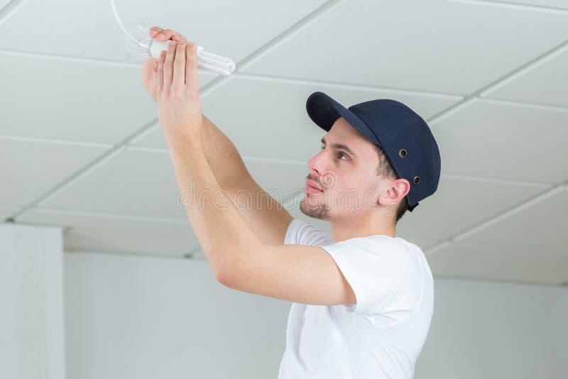 Handsome Young Builder Installing Light Bulb Indoors Stock Photo ...