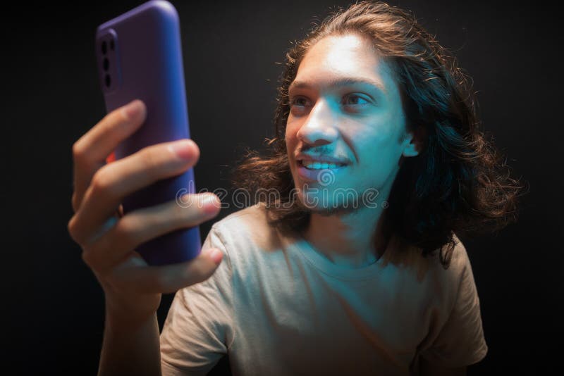 Handsome Young Caucasian Man Sitting Looking at His Cell Phone in His ...