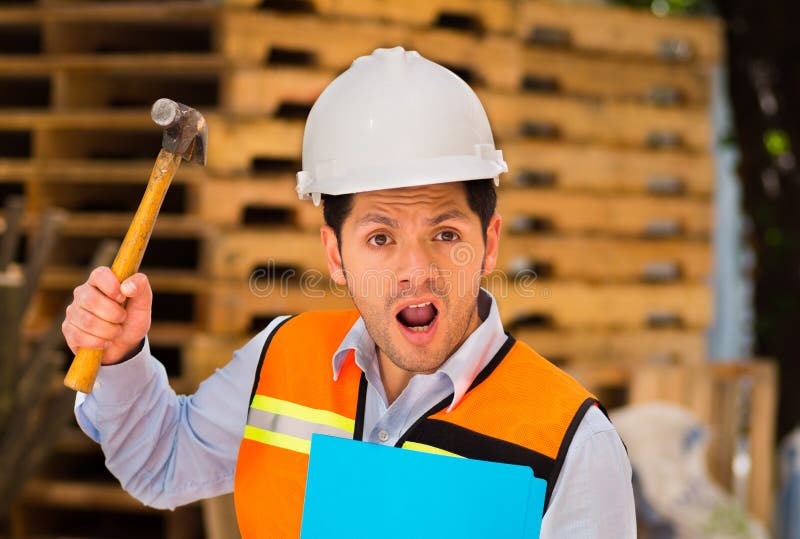 Handsome Young Engineer Holding a Folder and Hammer in His Hand at ...
