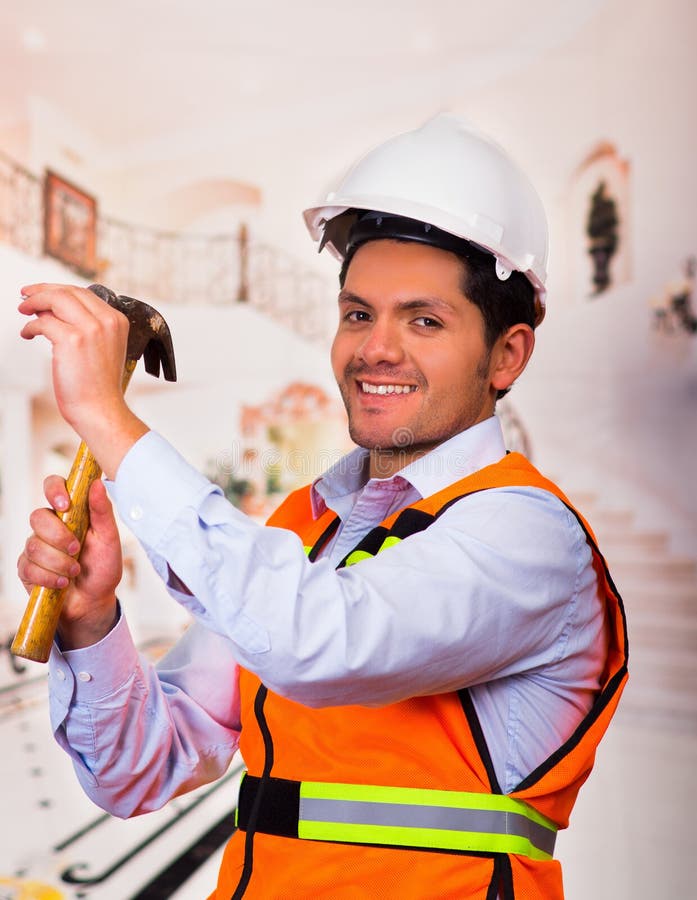Handsome Young Engineer Using a Hammer in His Hand at Construction Site ...