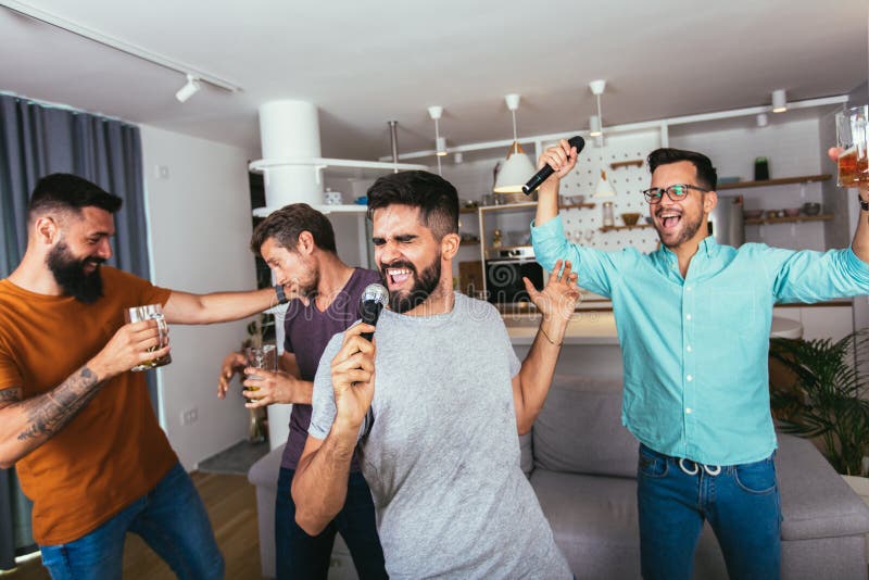Young Guy Singing with Microphone, Playing Karaoke with Friends in the ...