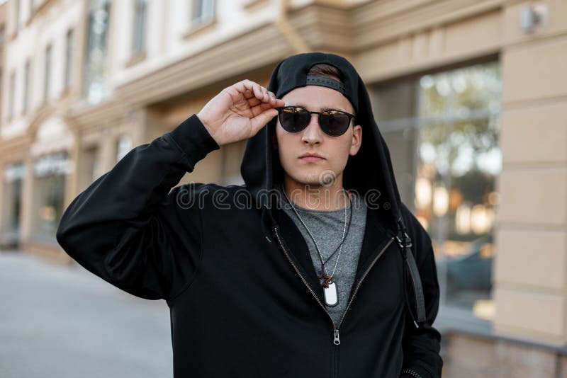 Handsome Young Hipster Man In Stylish Black Clothes In A Trendy Cap In