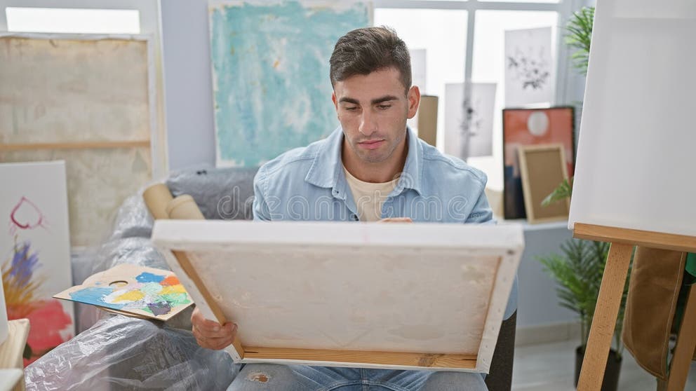 Handsome Young Hispanic Man, Deep in Thought, Masterfully Drawing in a ...