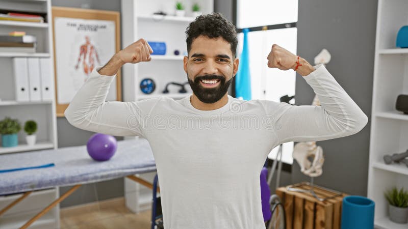 Handsome Young Hispanic Man Flexing Muscles Joyfully in a Modern ...