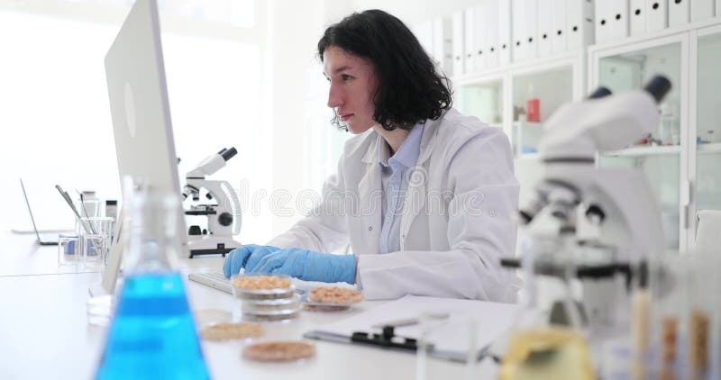 Handsome Young Laboratory Assistant Using Computer Working in ...