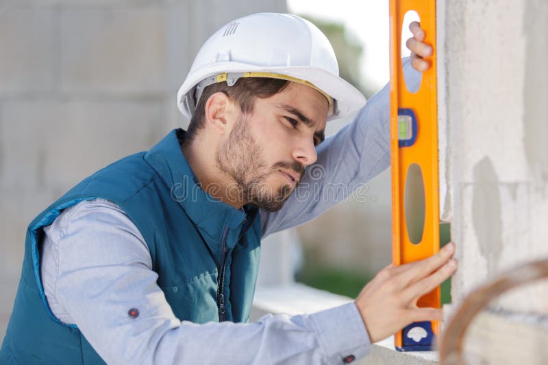 Handsome Young Laborer Measuring Wall with Level Tool Stock Image ...