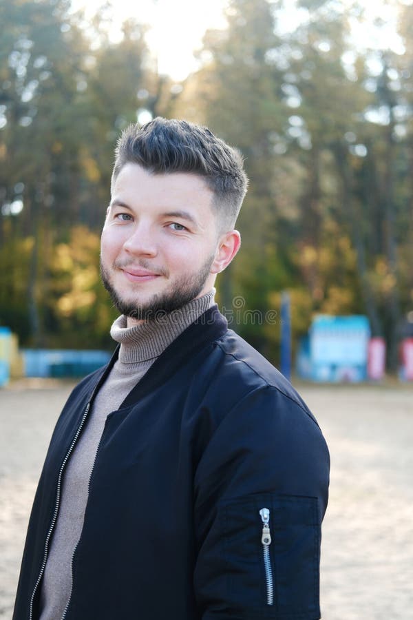 Handsome Young Man with a Beard and in a Black Jacket Posing on the ...