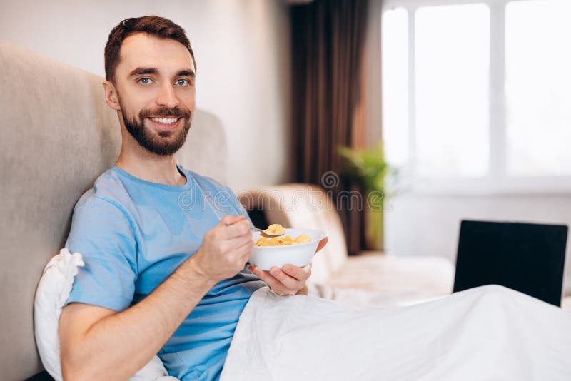 Handsome Young Man with Beard Smiling Eating Breakfast in Bed Look at ...