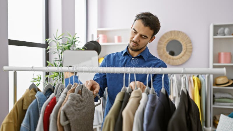 Handsome Young Man Browsing Clothing in a Modern Dressing Room Stock ...