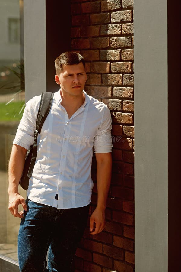 Handsome Young Man Carrying Backpack Near Walls of Building Stock Photo ...