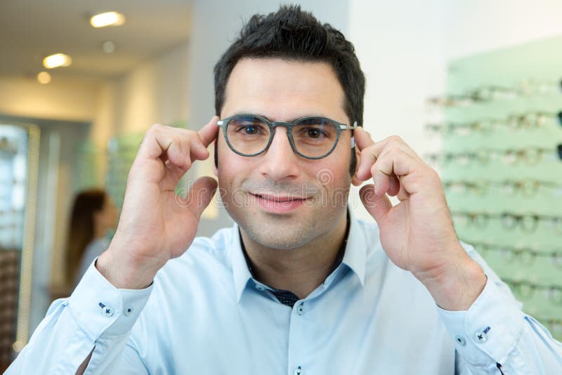 Handsome Young Man Choosing Eyeglasses Frame in Optical Store Stock ...