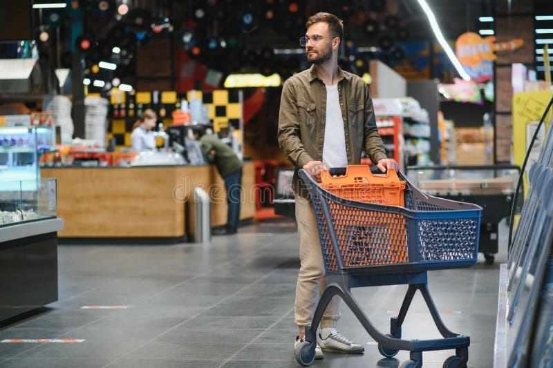 Handsome Young Man Choosing Food in the Supermarket. Stock Photo ...